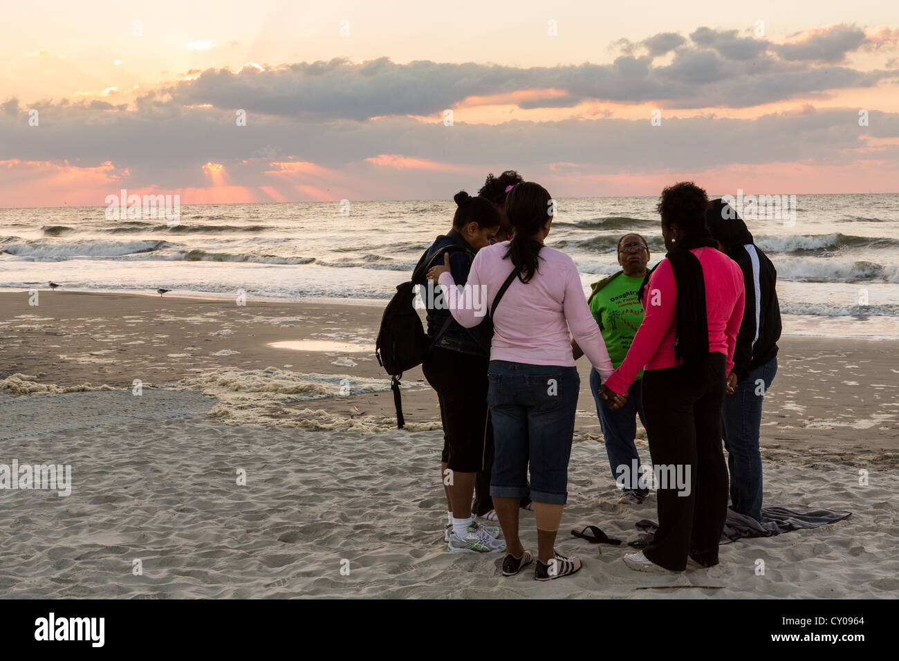 A group of women pray on the beach at sunrise on Hilton Head Island, SC ...