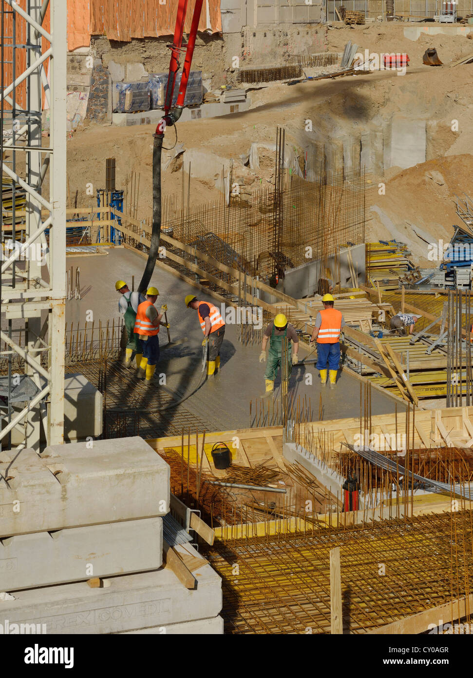 Large construction site, workers pouring concrete into an area ...