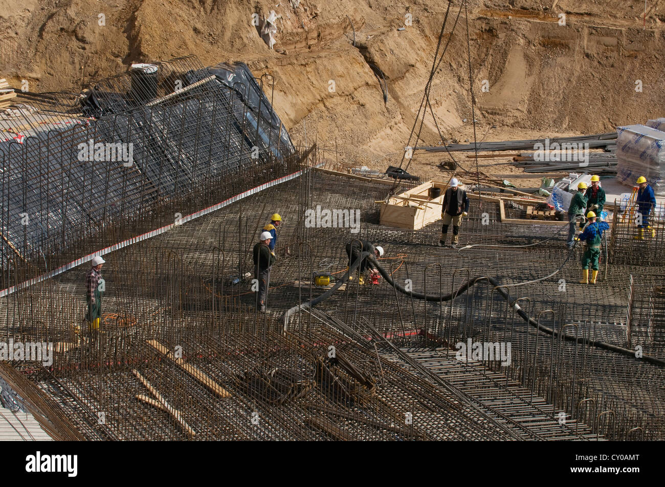Construction site, workers using a hose to fill the foundations with ...