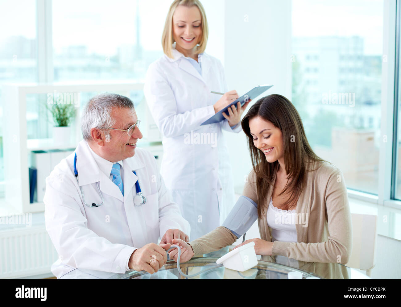Portrait of male practitioner measuring blood pressure in hospital ...