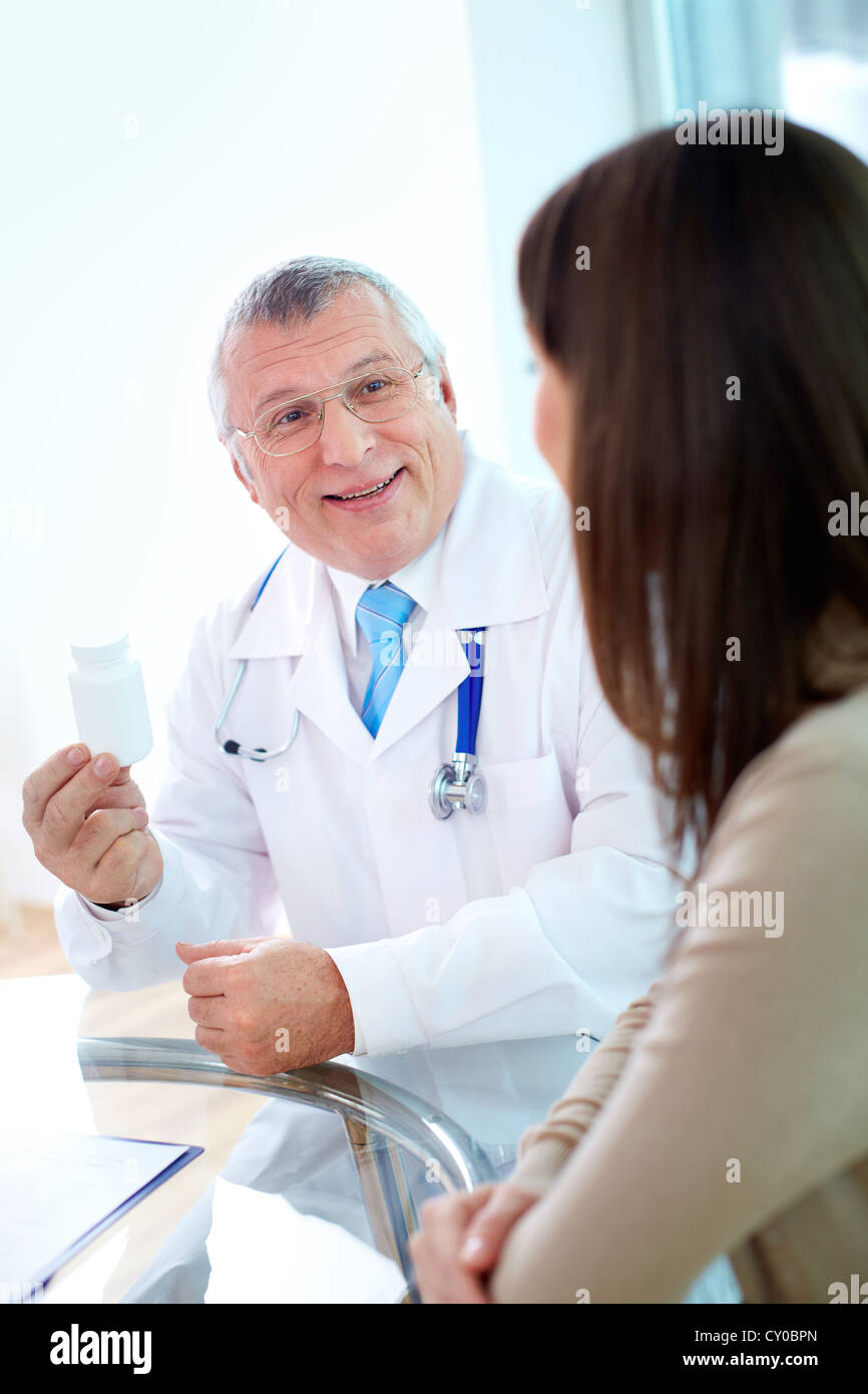 Portrait of confident practitioner prescribing vitamins to patient in ...
