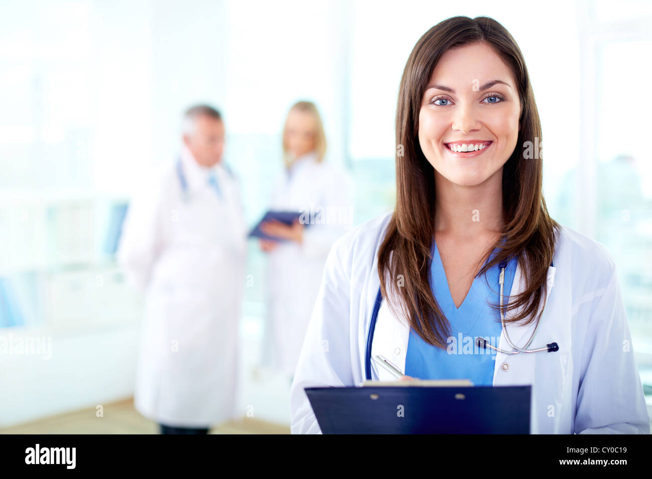 Portrait of pretty female practitioner looking at camera in working ...