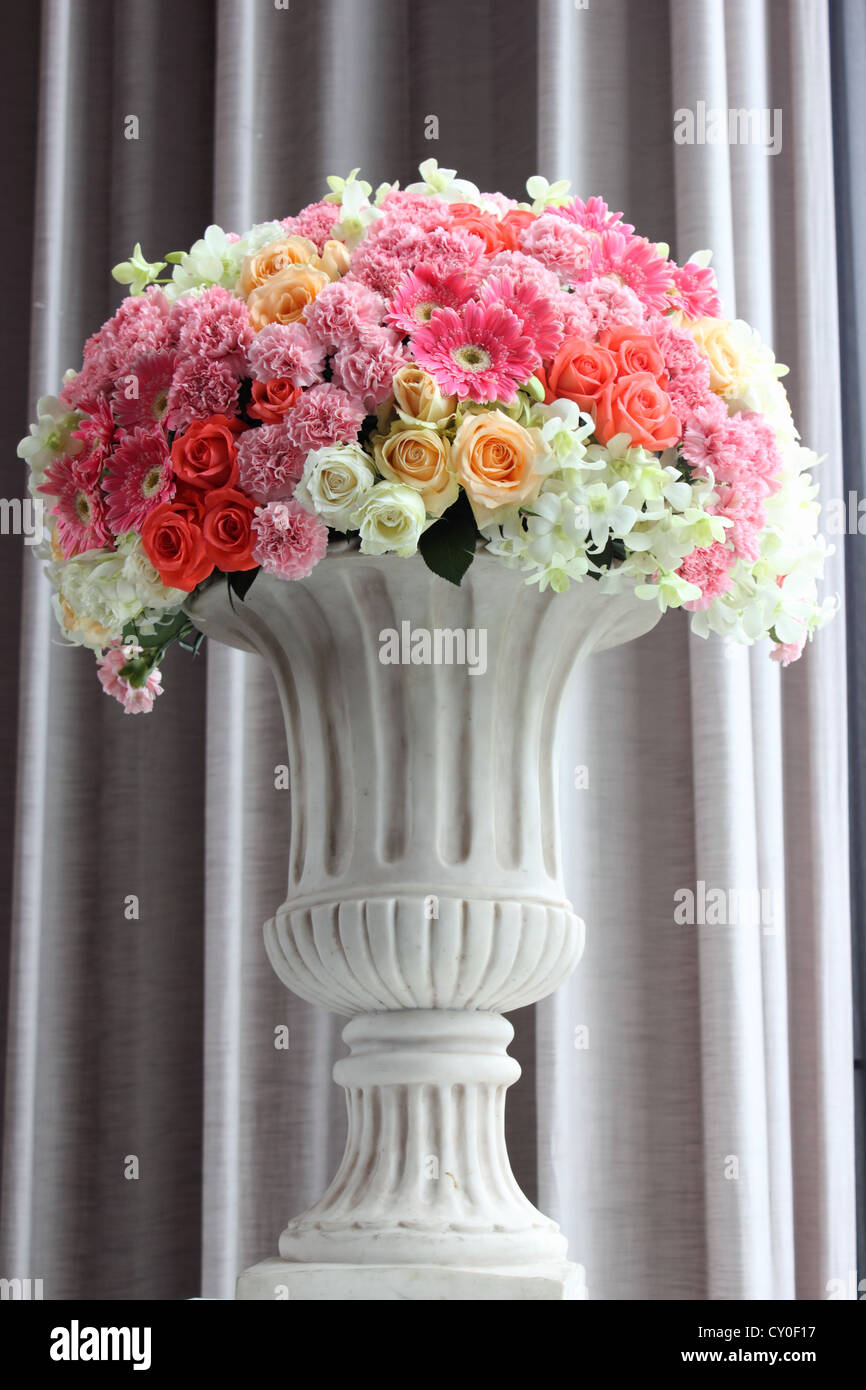Arrange flowers in a white roman vase Stock Photo - Alamy