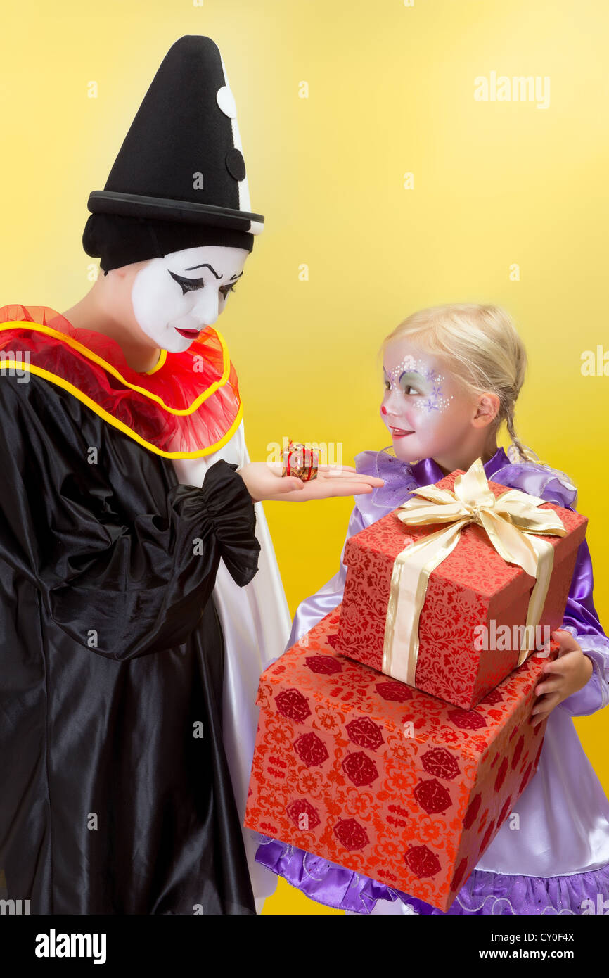 Happy little clown with big presents and sad pierrot with a small gift ...
