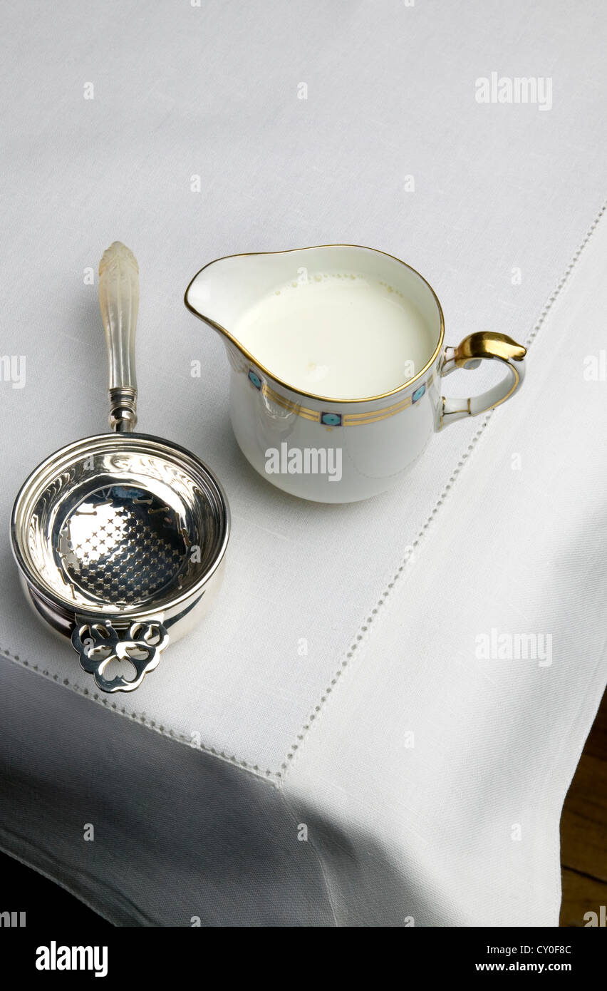 Milk jug and tea strainer Stock Photo - Alamy