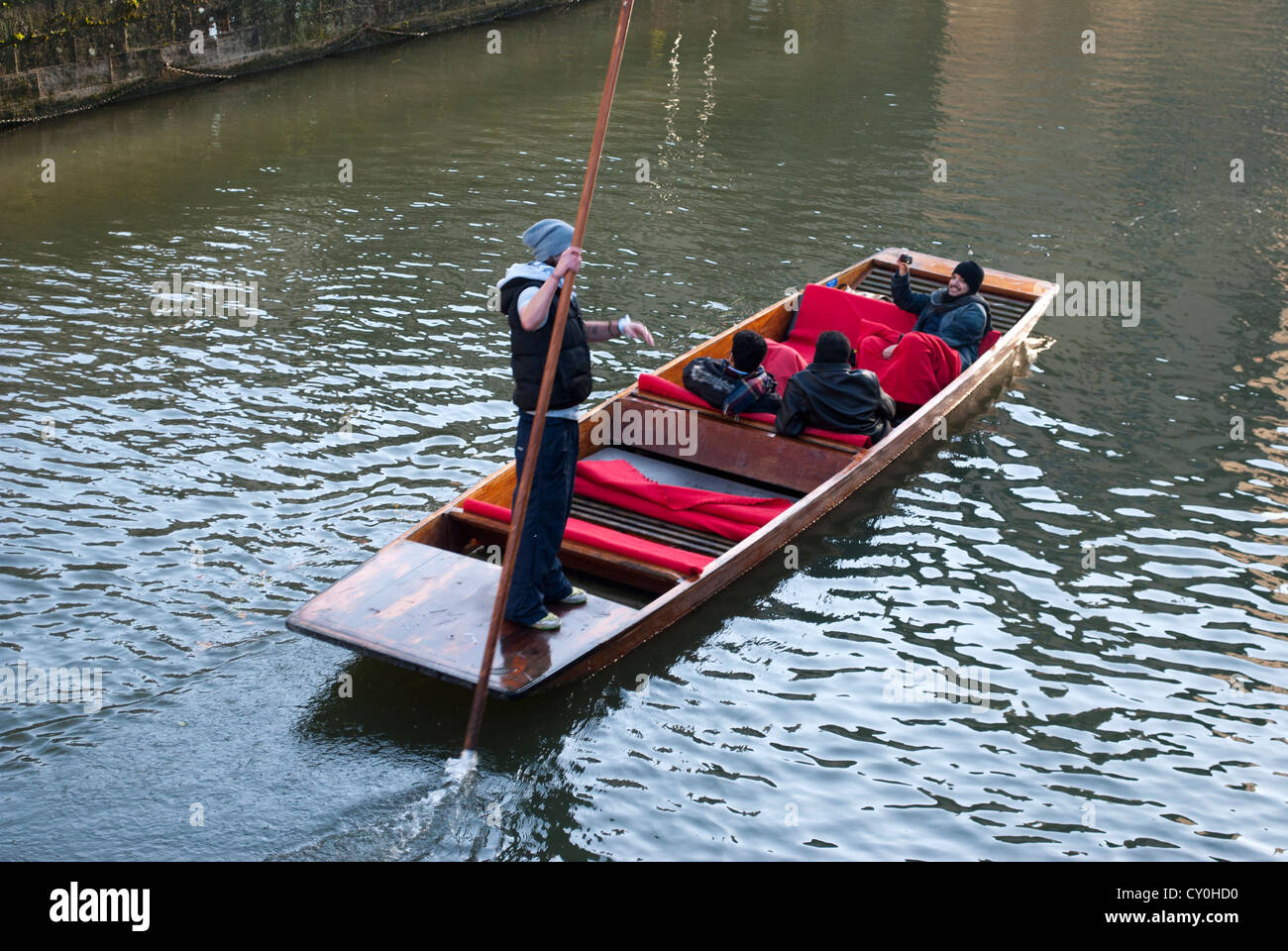 Large punt with red seats on the Cam in Cambridge looking down from a ...