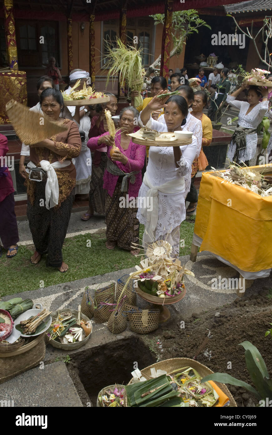 Family members perform protection rites at a funerary ceremony in Ubud ...