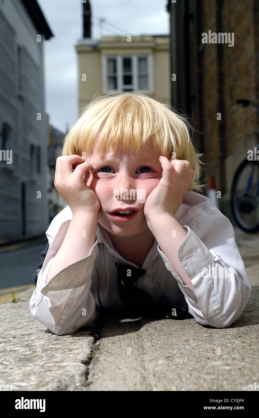 Young Boy Laying on Pavement Stock Photo - Alamy