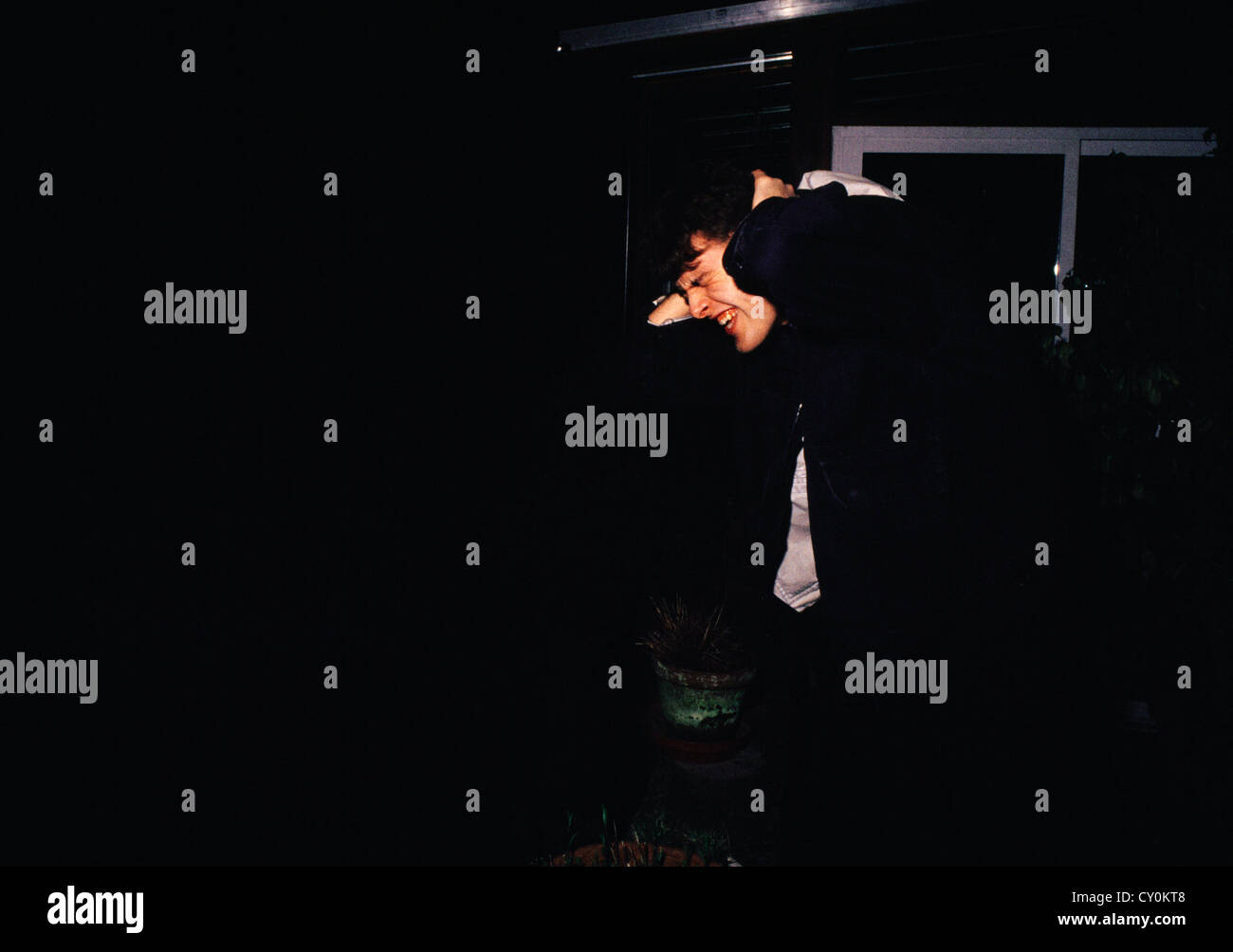 Man Screaming With Hands Covering His Ears Outside At Night Stock Photo ...