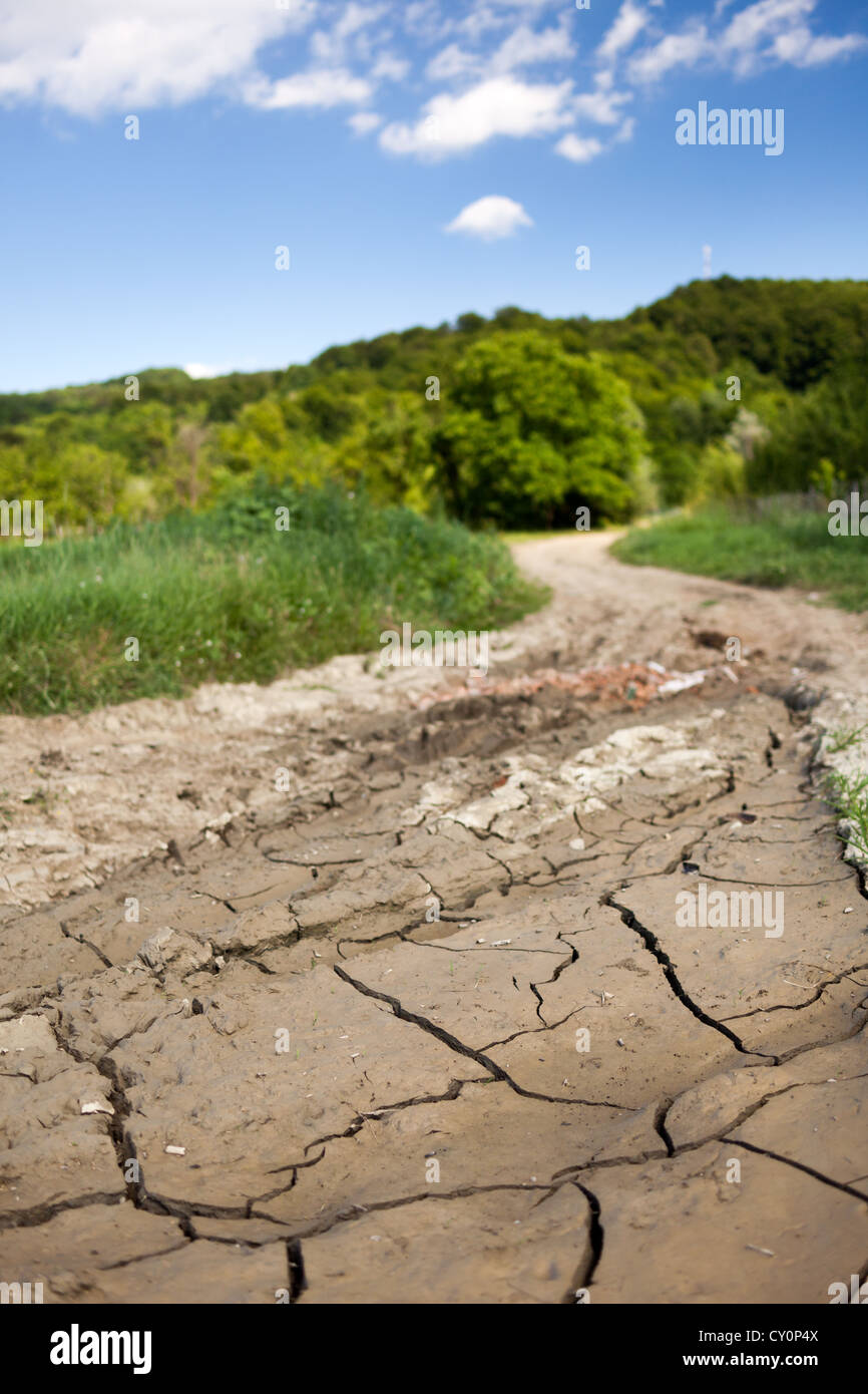 Cracked dried ground road in the countryside Stock Photo - Alamy