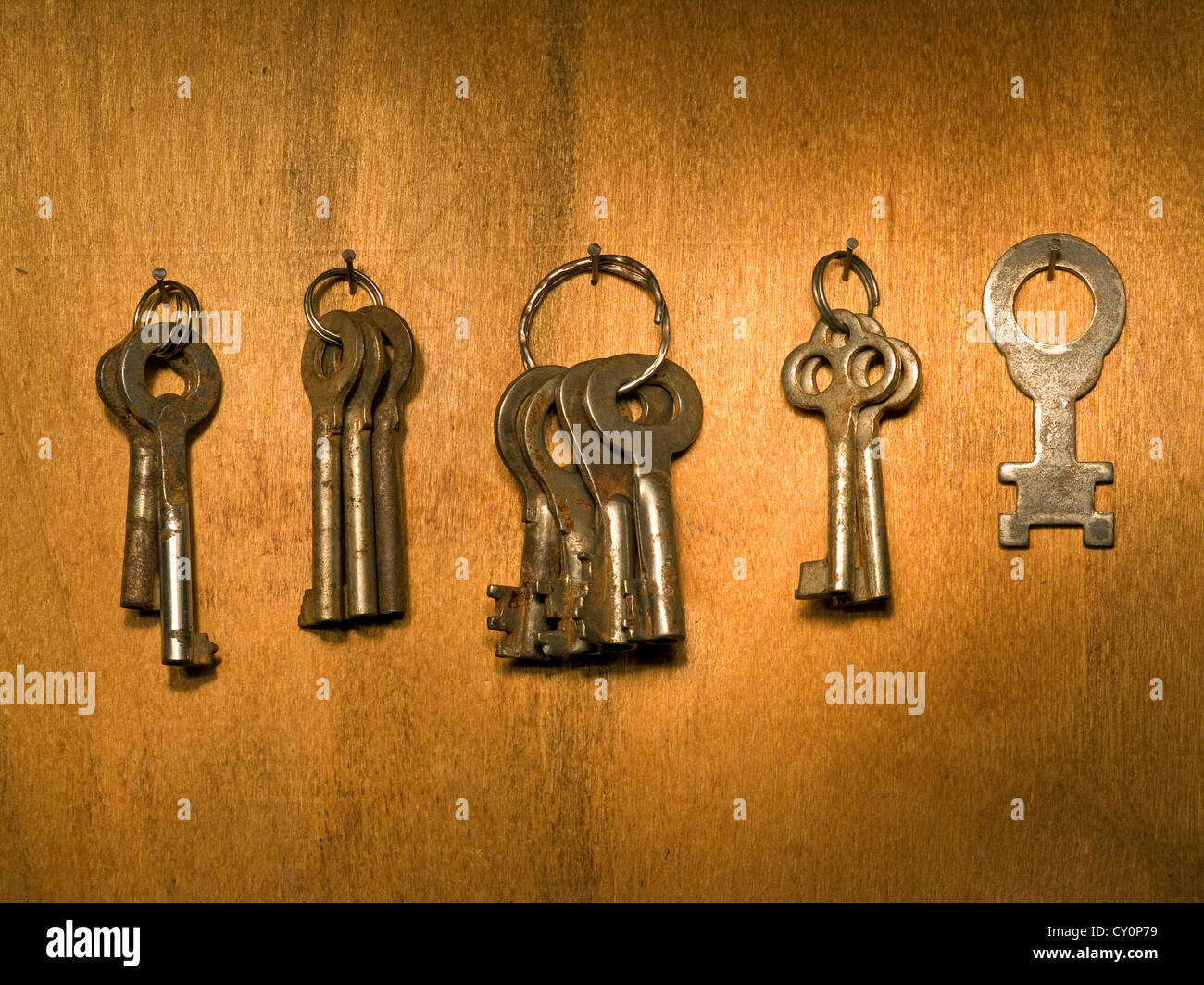 Bunches of old keys on a wooden wall surface Stock Photo - Alamy