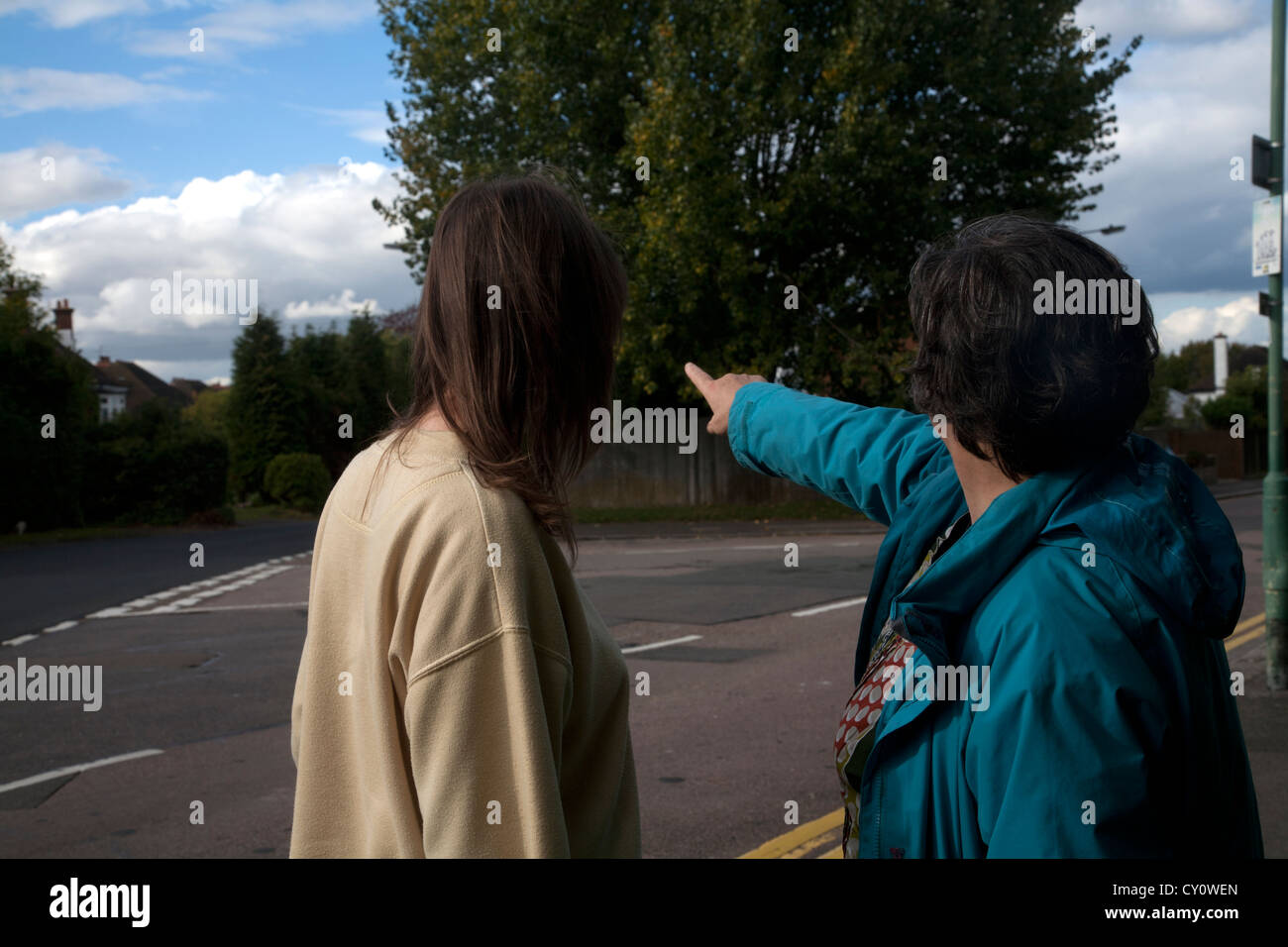 Woman pointing in the street and giving directions to another woman ...