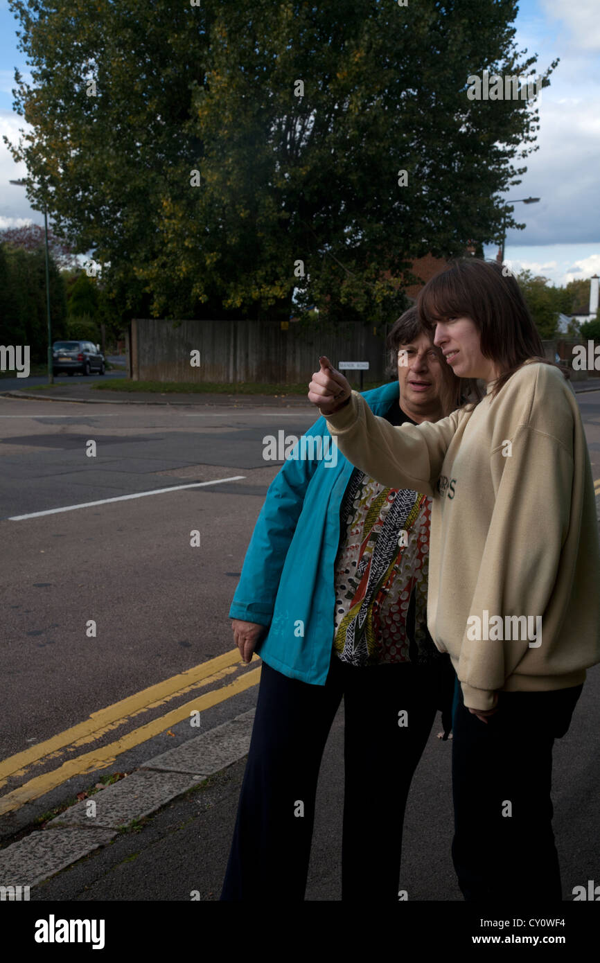 Woman pointing in the street and giving directions to another woman ...