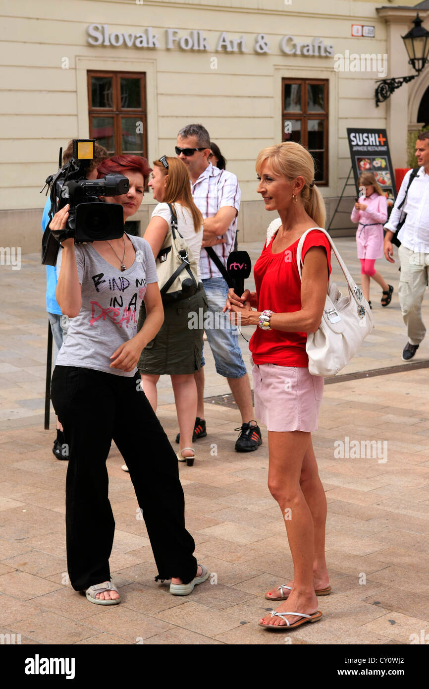 Female TV Reporter and film crew interviewing passerby in Bratislava ...