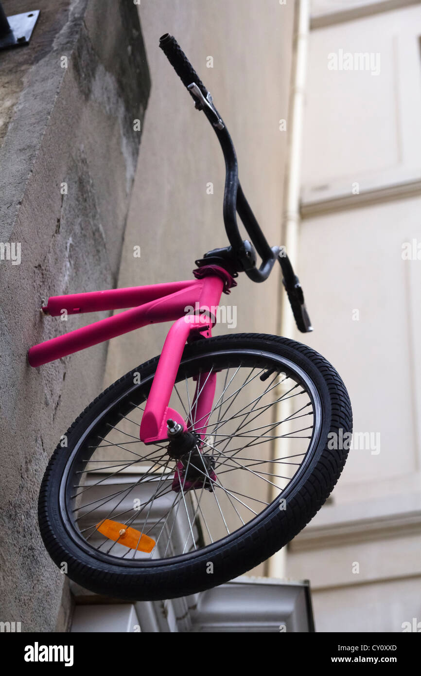 Half a bicycle attached to wall—seemingly embedded—in Marais region of ...