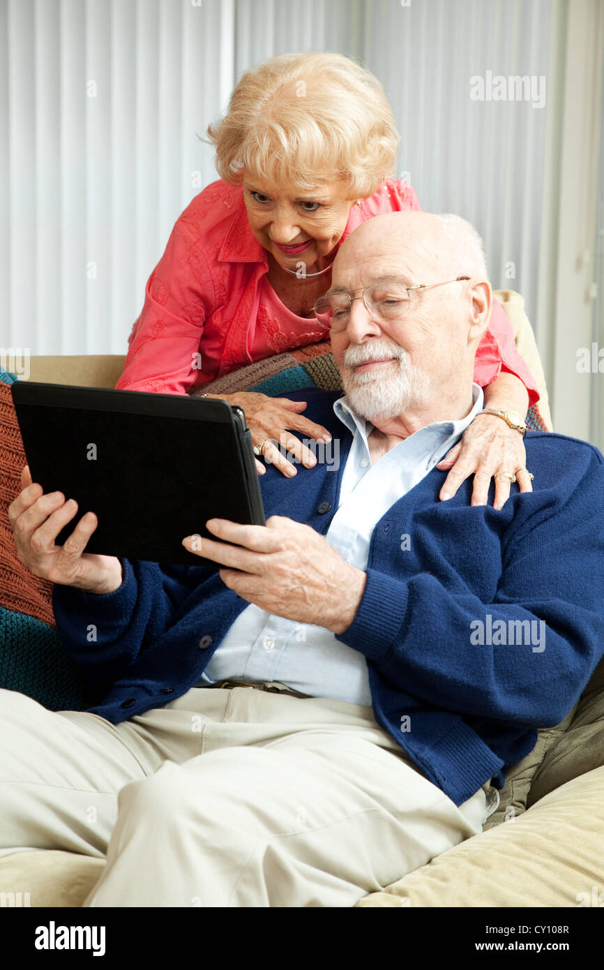 Senior couple relaxing at home, using their tablet PC Stock Photo - Alamy