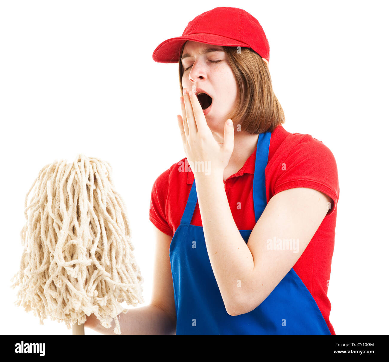 Tired teenage girl in her work uniform, holding a mop and yawning ...