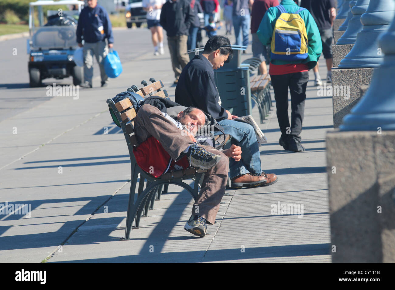 Homeless man sleeping on city bench Stock Photo - Alamy