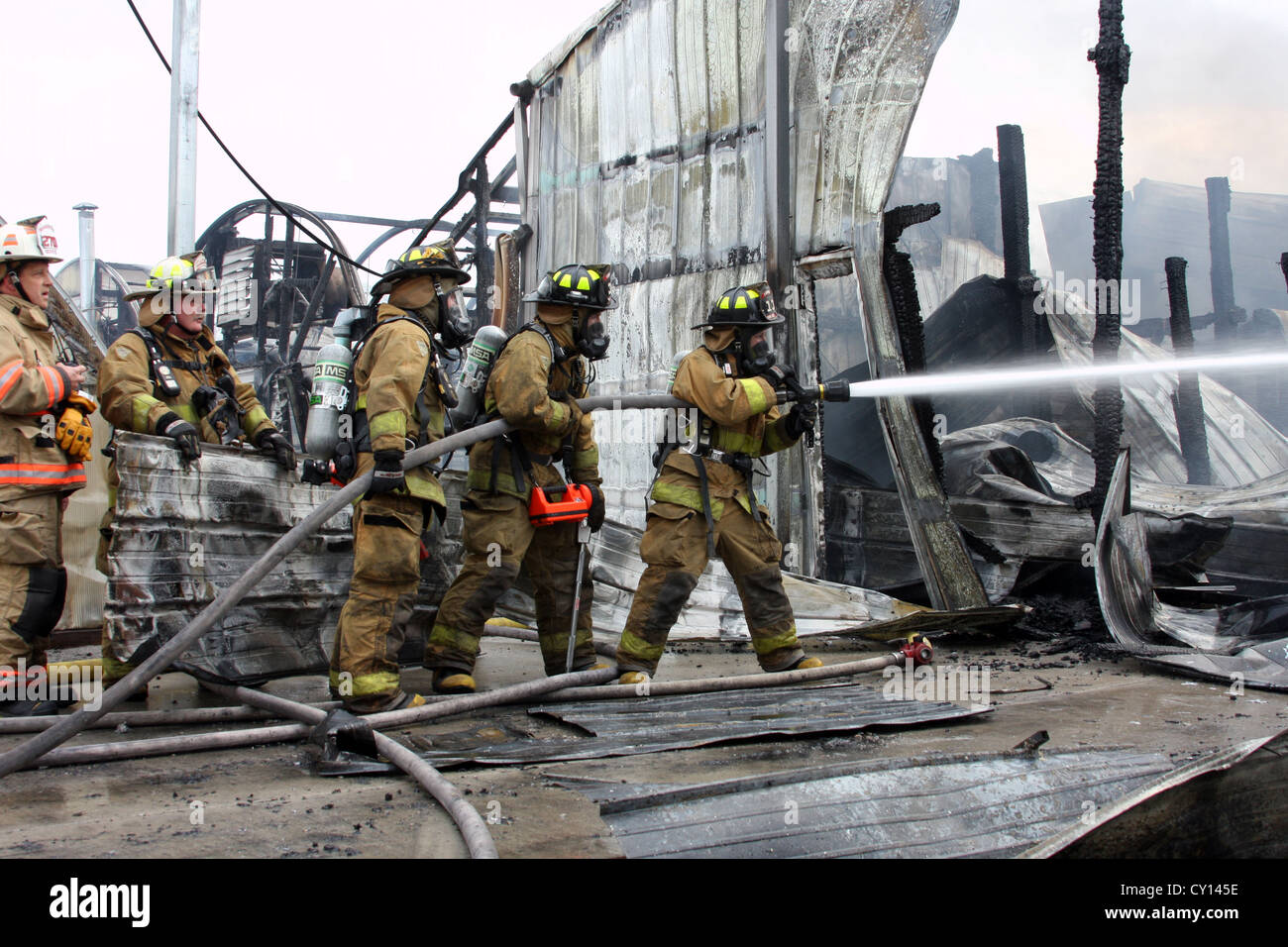 Firefighters putting out a fire in an industrial building Stock Photo ...