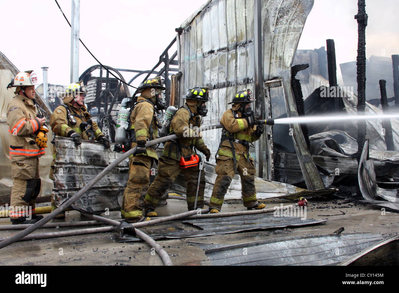 Firefighters putting water on an industrial fire Stock Photo - Alamy