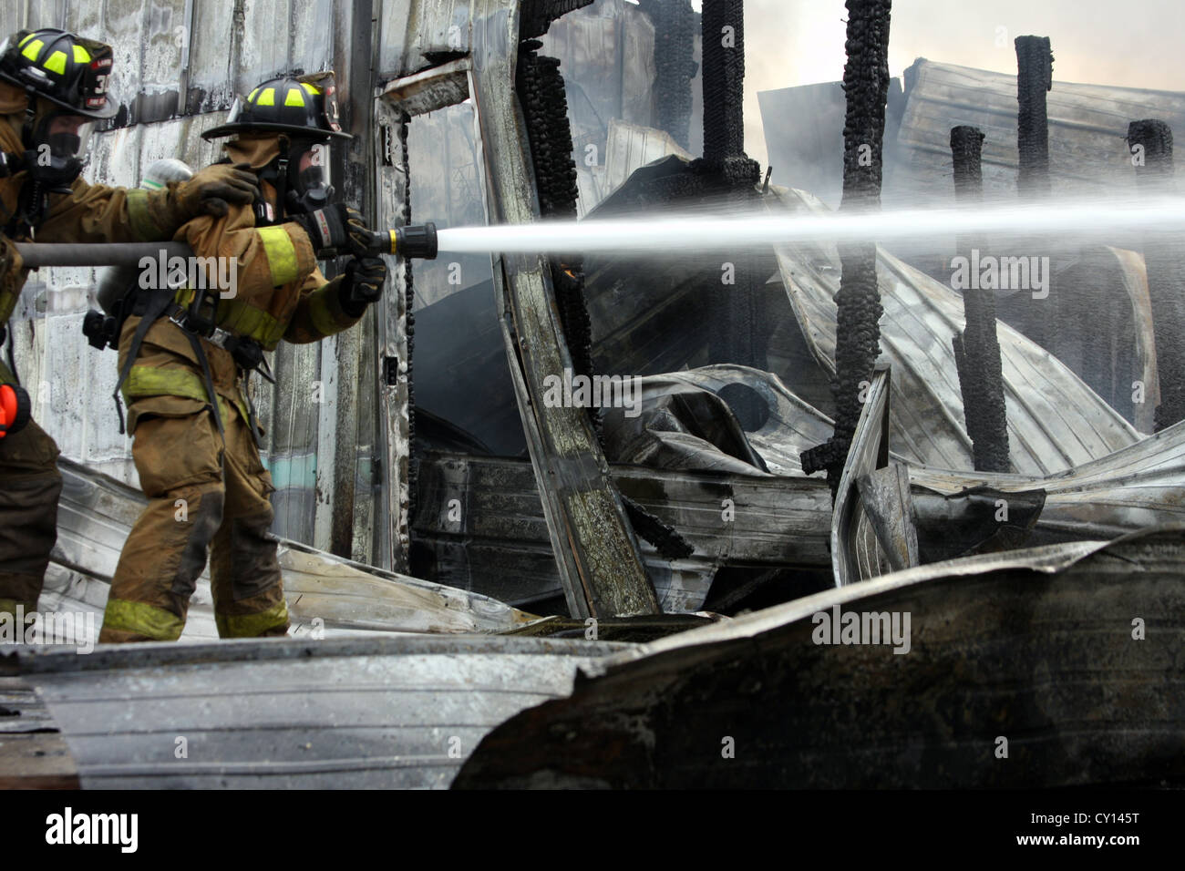 A firefighting team putting water on a fire in an industrial building ...