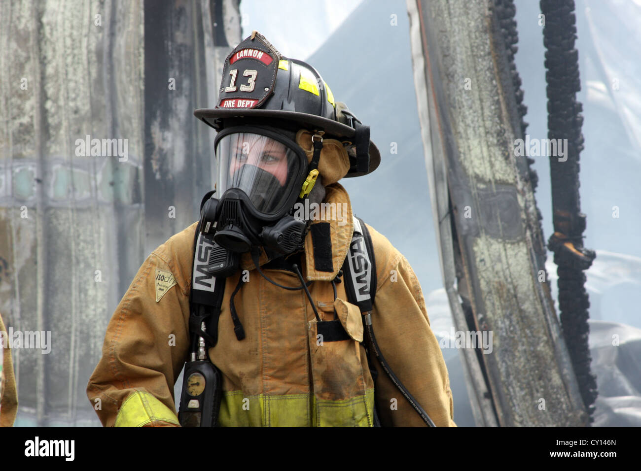 A woman firefighter at the scene of an industrial building fire ...