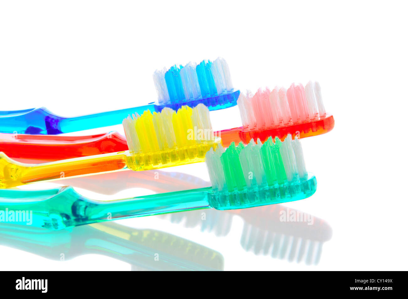 Closeup of four toothbrushes of different colors on a white background ...