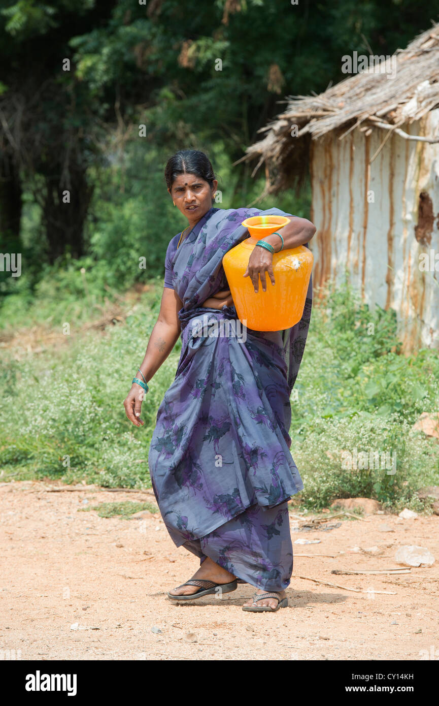 Rural Indian village woman collecting water from a communal water tank ...