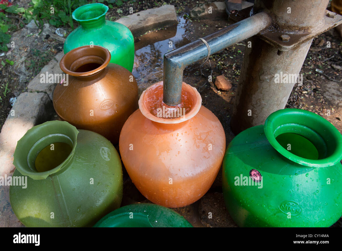 Filling plastic indian water pots from a rural water pump. Andhra ...