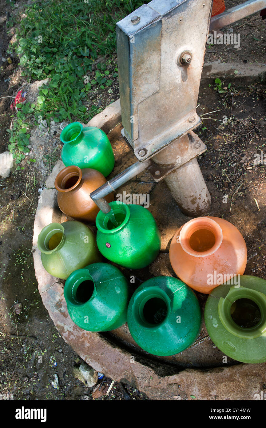 Filling plastic indian water pots from a rural water pump. Andhra ...