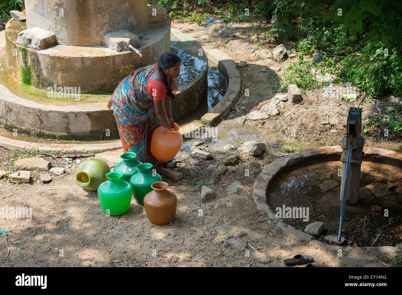 Rural Indian village woman collecting water from a communal water tank ...