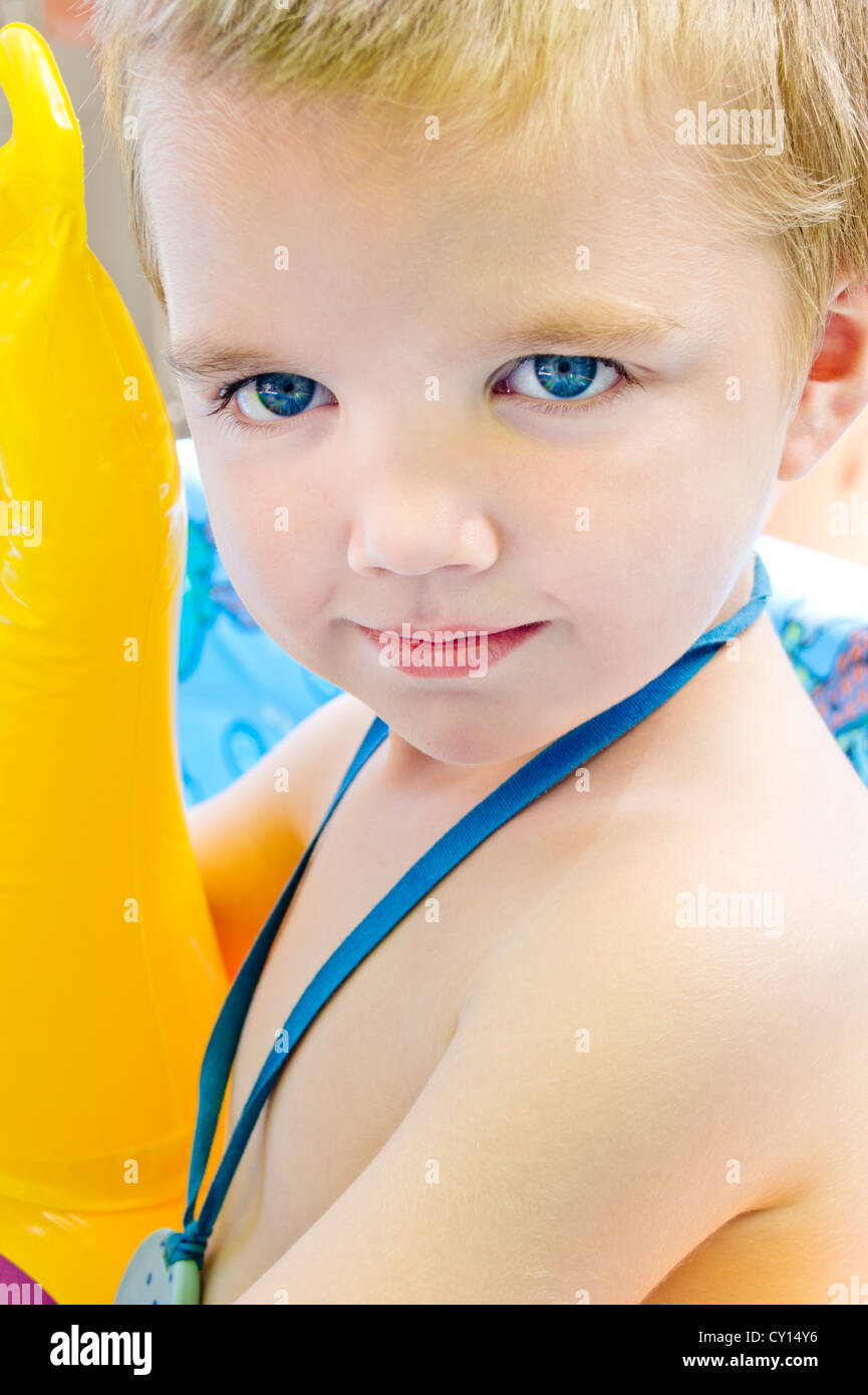 Close-up of a beautiful five-year-old autistic boy playing in a wading ...