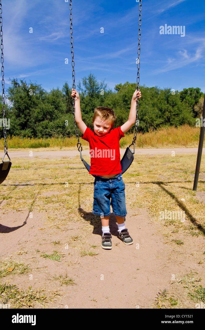 A young autistic boy becomes distracted while playing with a swing and ...