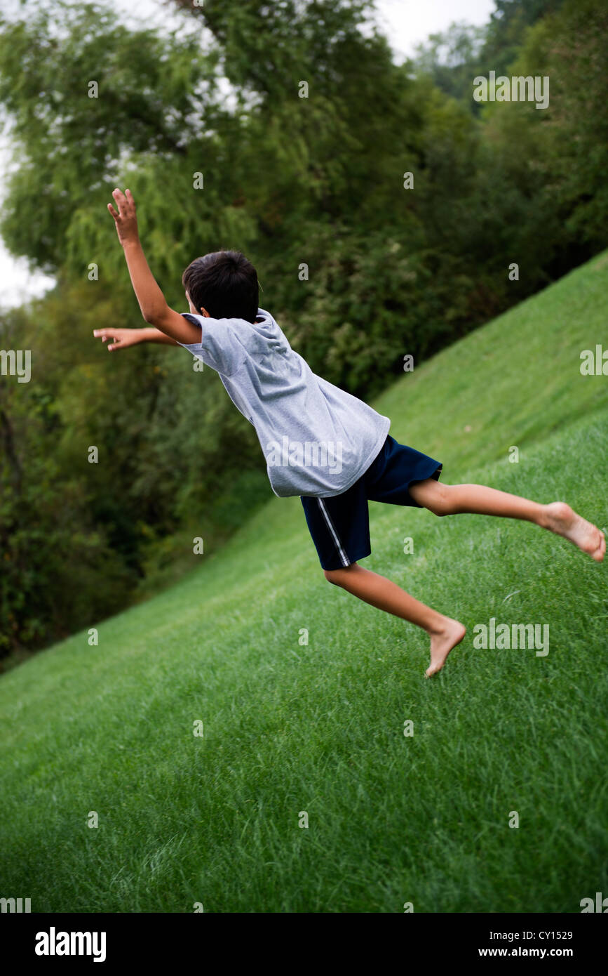 Young boy running and jumping in the air outdoors Stock Photo - Alamy