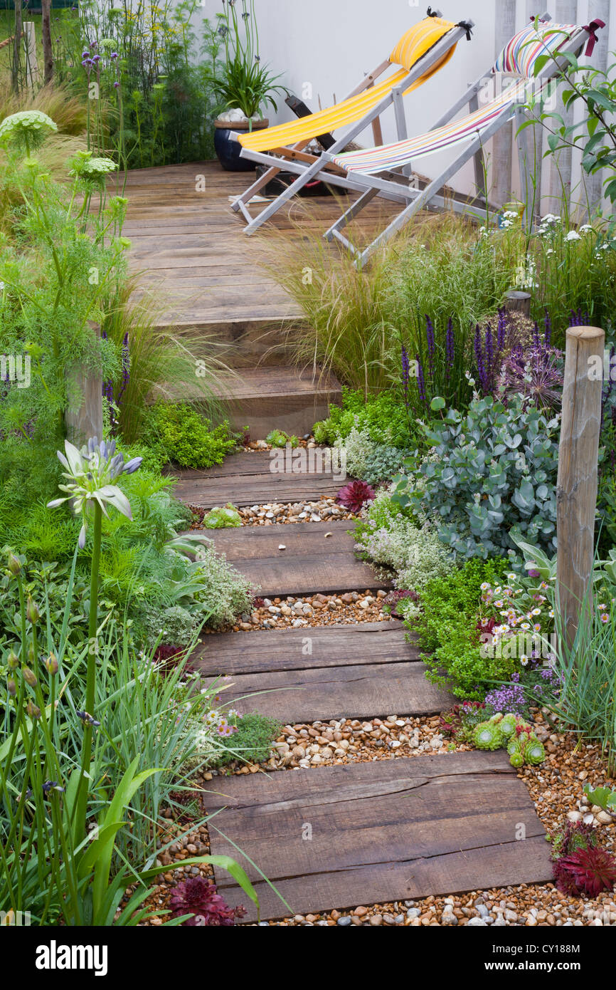 Extensive planting of grasses around timber decked patio area and above ...
