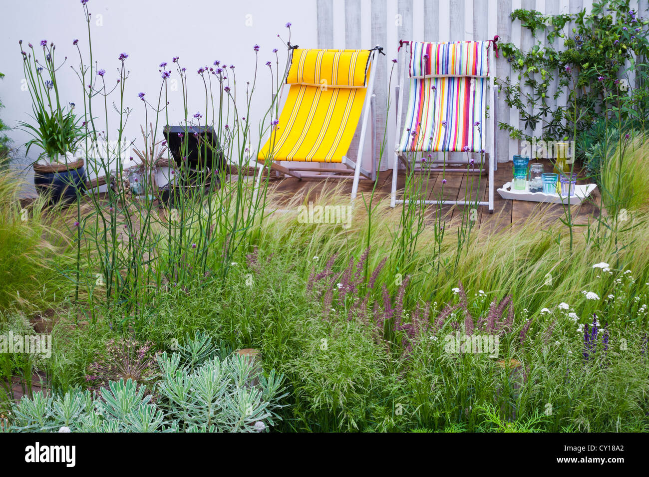 Extensive planting of grasses around timber decked patio area and above ...