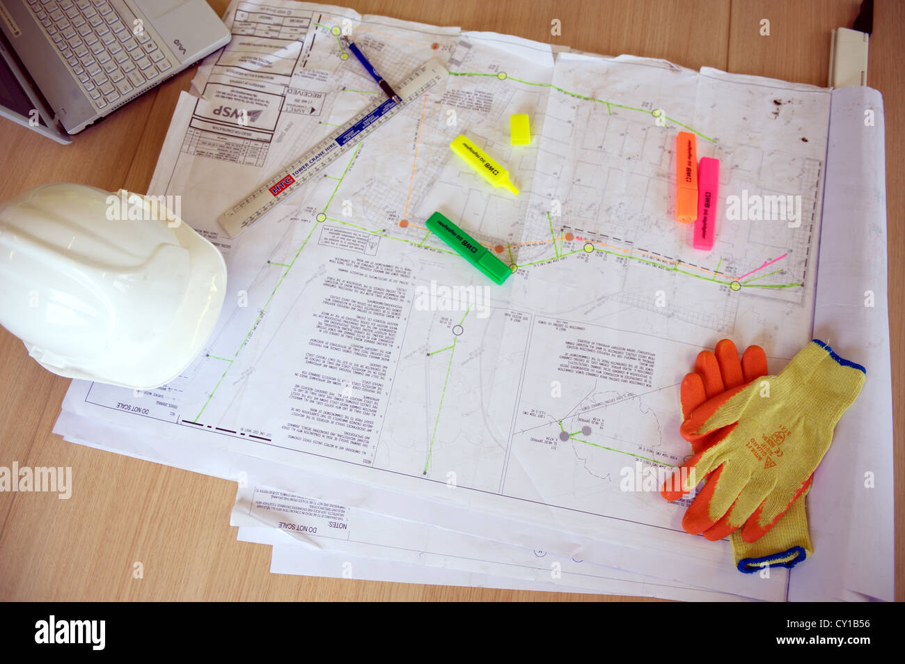 Architectural plans and construction equipment on a desk in a site ...