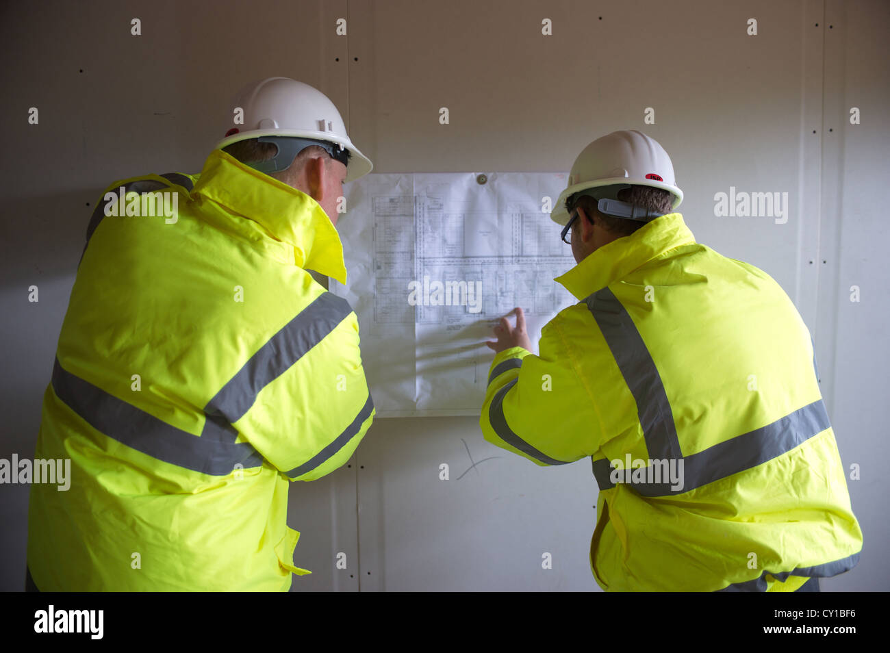 Two workmen look architectural plans hi-res stock photography and ...