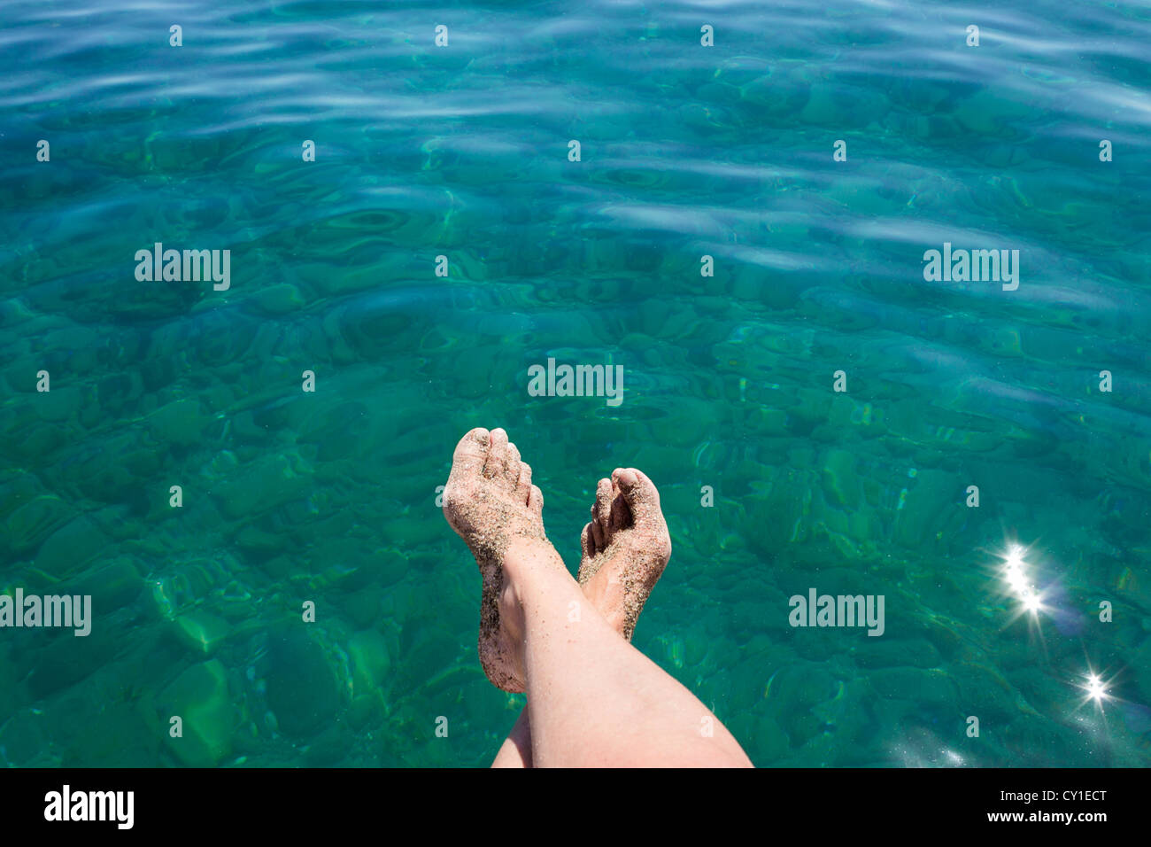 Woman's legs and feet hanging over the sea. Marbella, Costa del Sol ...