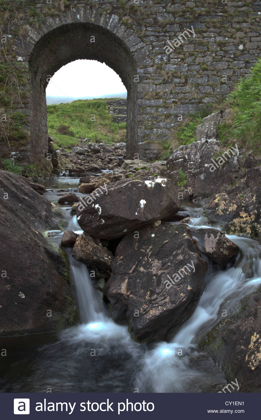 A stream passes under and ancient bridge on the Beara Peninsula Stock ...