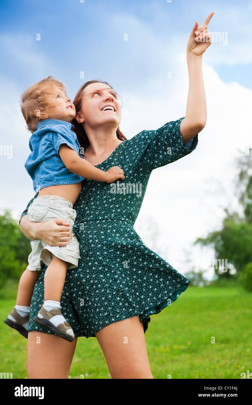 Mother holding her kid and pointing at something Stock Photo - Alamy