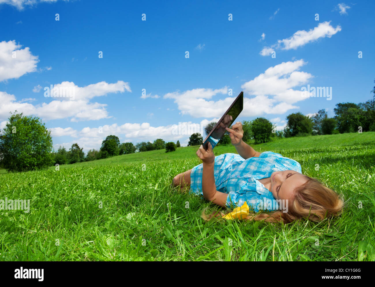 pretty girl laying on the green lawn and browsing internet Stock Photo ...