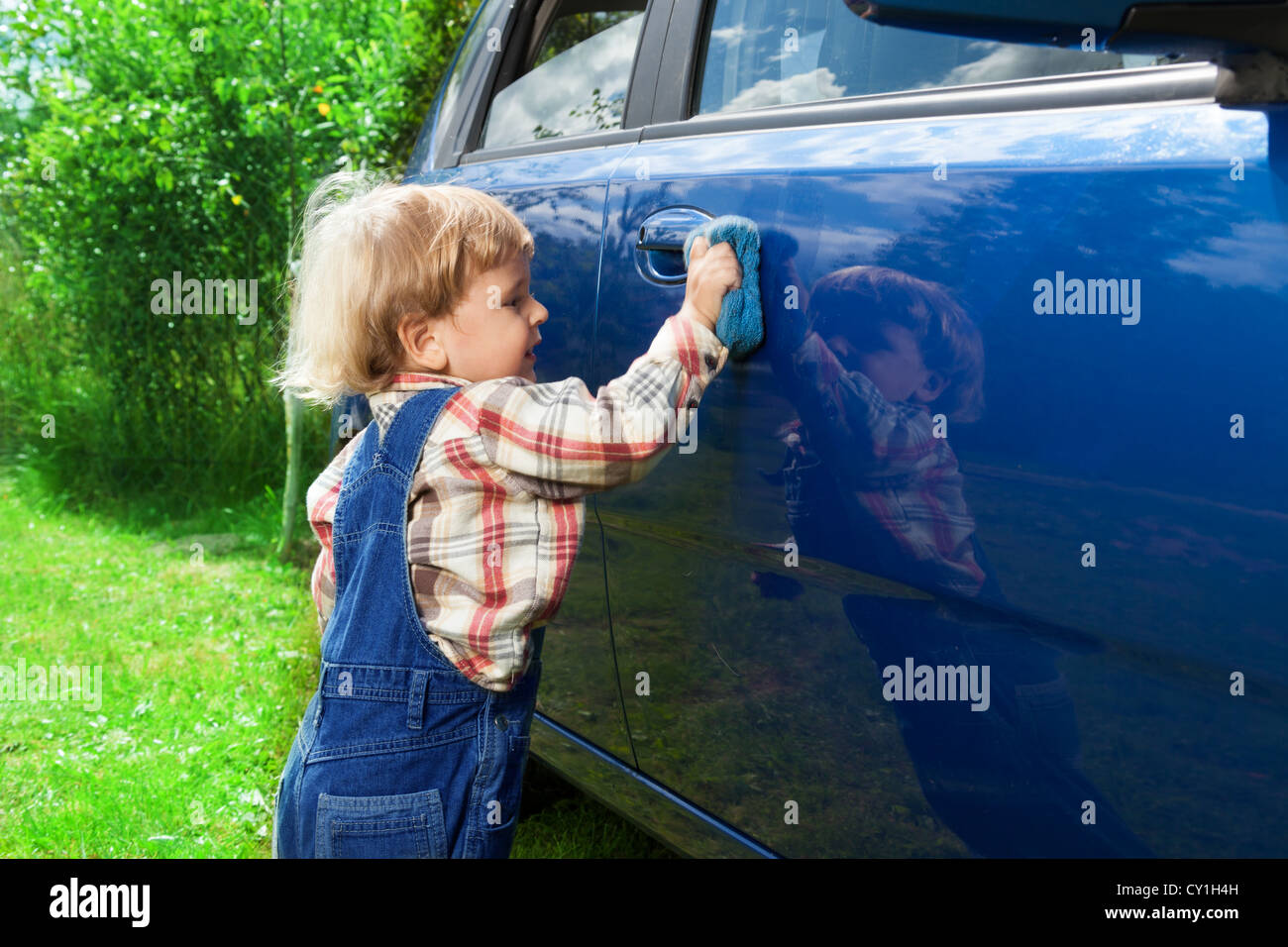 adorable 2 years old washing blue car Stock Photo - Alamy