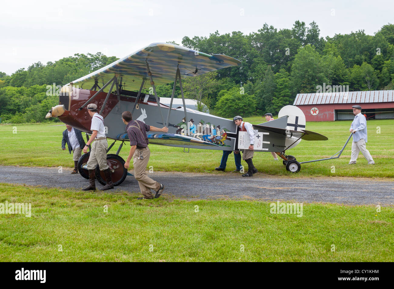 A group of men move an antique biplane from an airfield Stock Photo - Alamy