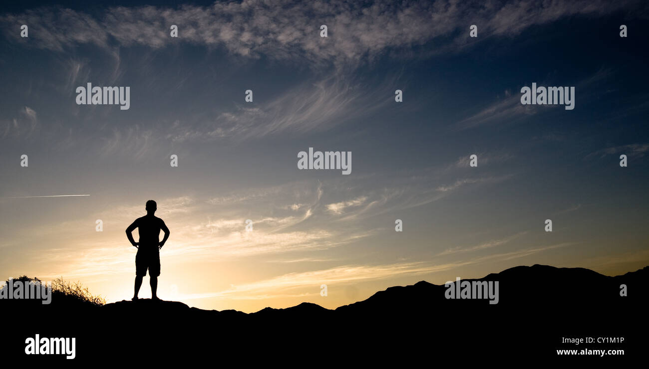 A man standing up in front of a sunset Stock Photo - Alamy