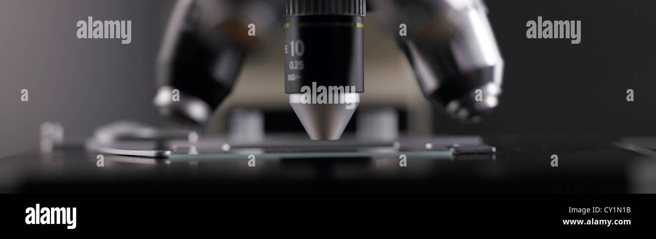 Lenses on the turret of a research microscope with glass slide on stage ...
