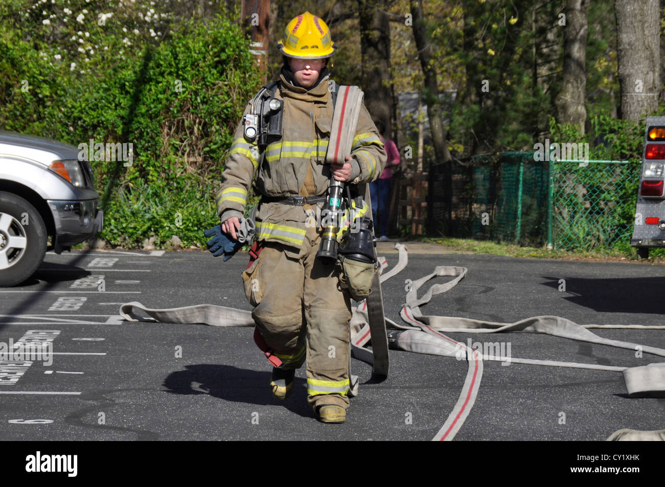 Firefighter carrying a hose Stock Photo - Alamy