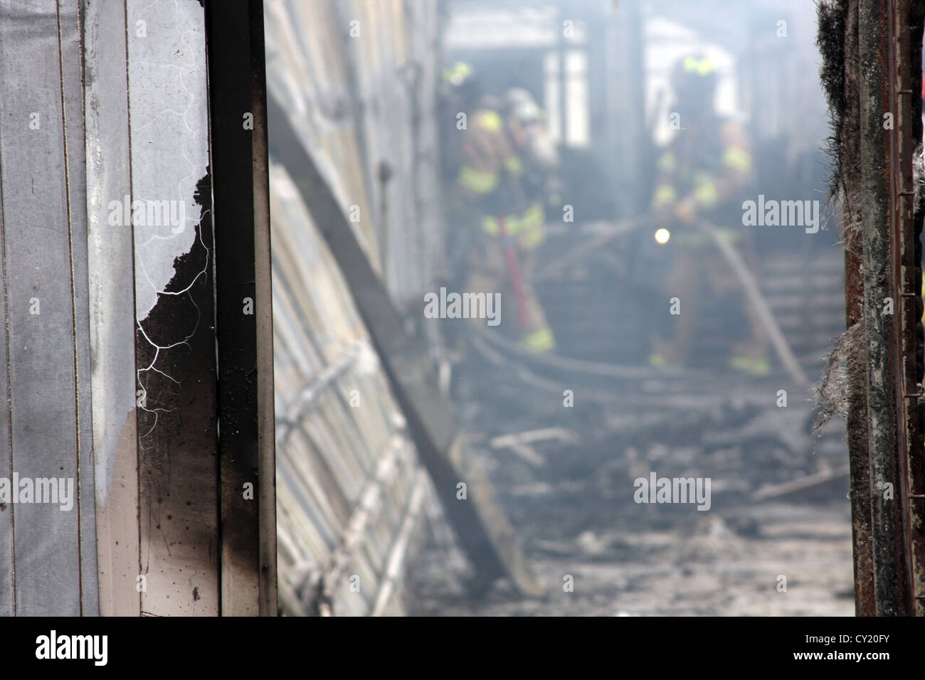 Blurred image of Firefighters inside the burnt out greenhouse building ...
