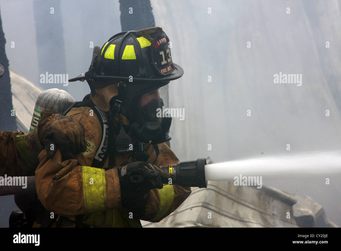 Firefighter putting out fire with hose hi-res stock photography and ...