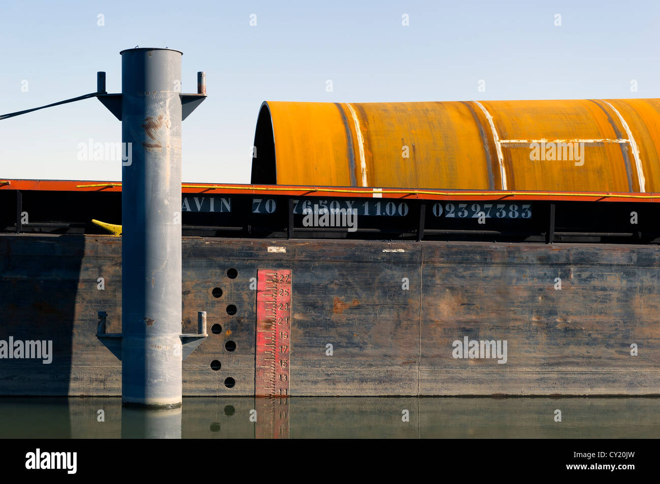 barge carrying a rusty pipe part Stock Photo - Alamy